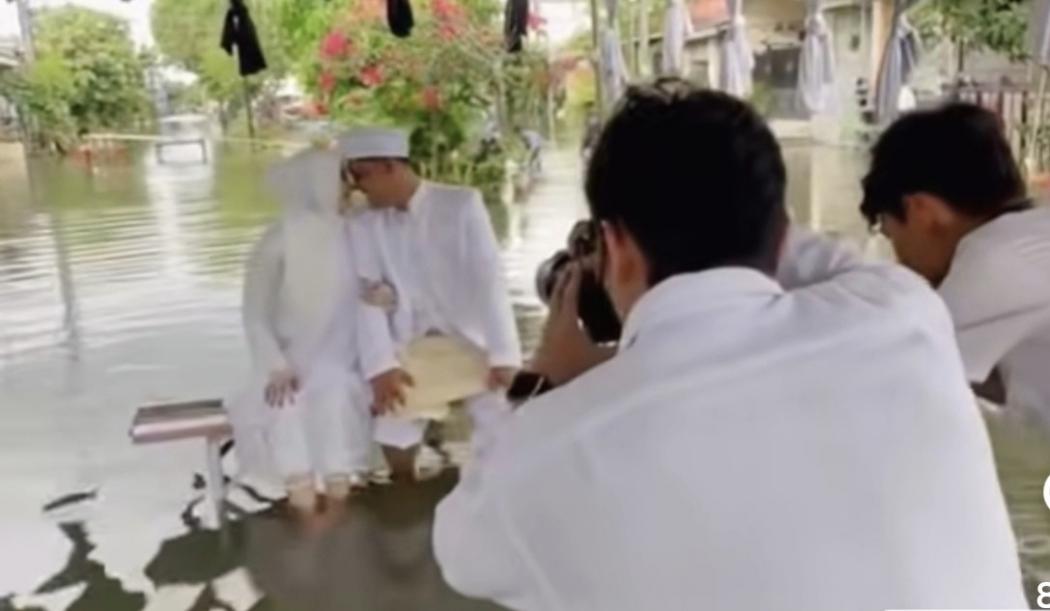Viral Sepasang Pengantin Foto Pernikahan di Tengah Banjir, Netizen: Ala-Ala Pantai Banget!