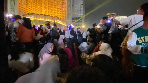 Momen Warga Gelar Tikar Saksikan Perayaan Tahun Baru 2024 di Bundaran HI